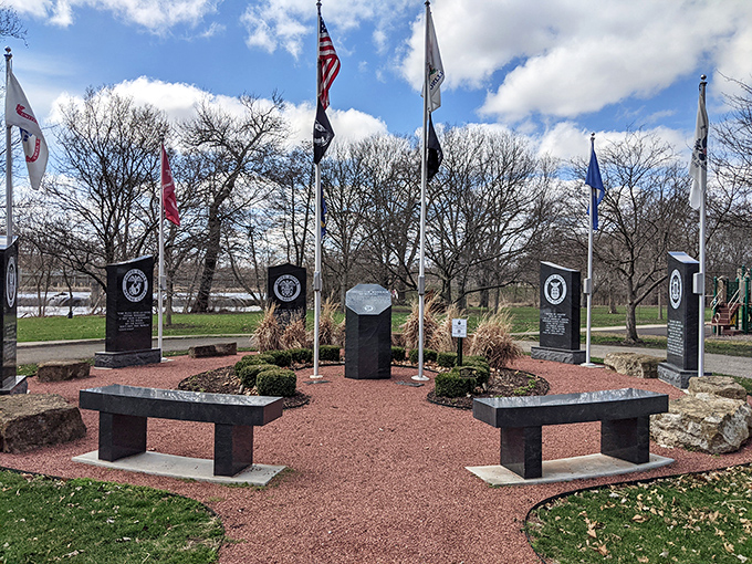 Silent sentinels of remembrance stand guard at the veterans' memorial, honoring those who served while visitors reflect in quiet respect.