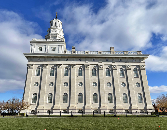 The majestic Nauvoo Temple stands as a gleaming limestone monument to faith and craftsmanship, its intricate details visible from every angle.