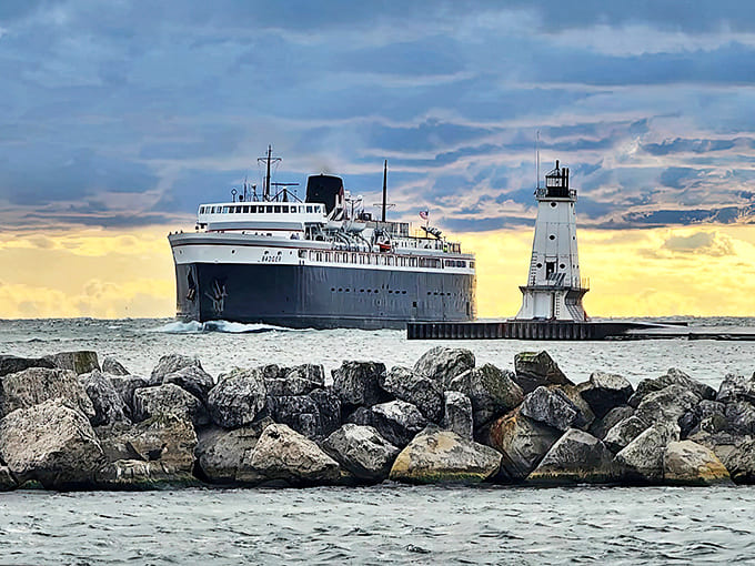 The mighty SS Badger steams past the lighthouse, carrying passengers across Lake Michigan just as it has since Eisenhower was president.