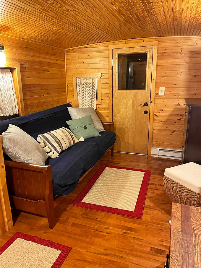 Warm pine paneling creates a cocoon of comfort in the living area, where every inch tells a story of ingenious transformation.