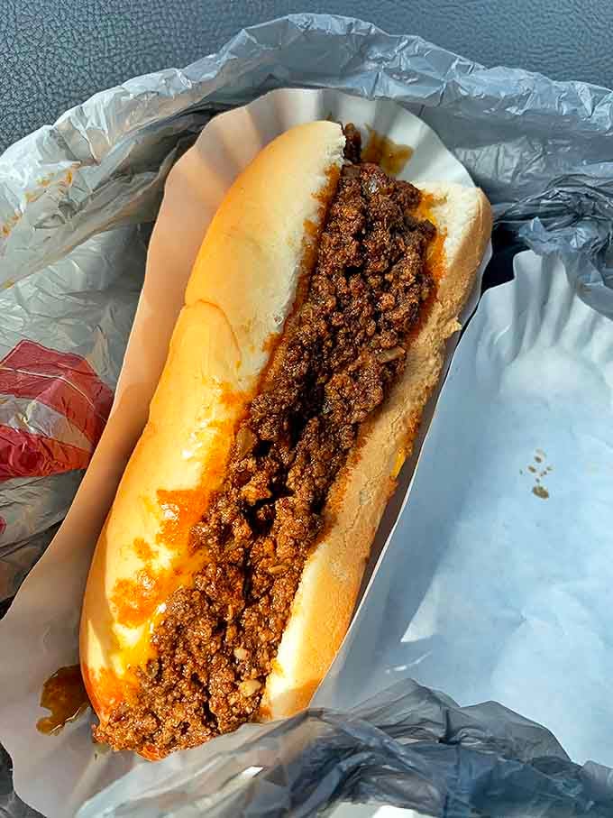 This isn't just any chili dog &ndash; it's an architectural masterpiece of beef, sauce, and spices that demands to be devoured with both hands and zero regrets.