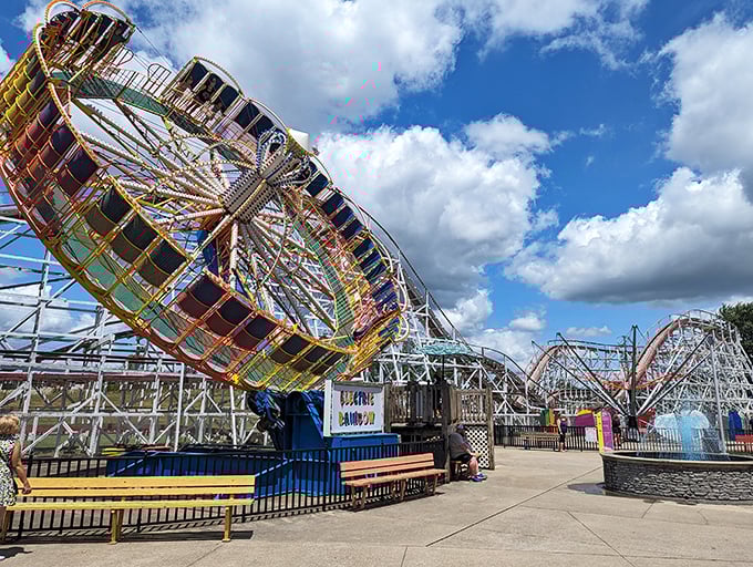 The Electric Rainbow whirls with kaleidoscopic brilliance, spinning riders into a dizzying dance of color and motion against the summer sky.