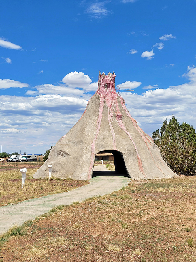 The pink volcanic-inspired structure invites explorers through its cavernous entrance, promising prehistoric adventures within its stone walls.