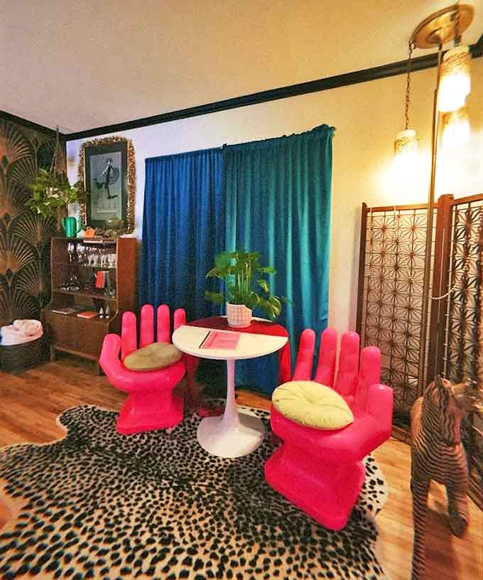 These aren't just hand-shaped chairs &ndash; they're conversation starters with fingers. Pink palm thrones await your stories against teal curtains and leopard print.