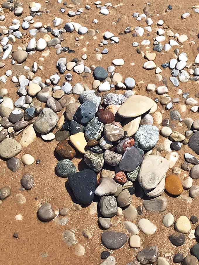 Nature's mosaic: Colorful pebbles create an ever-changing artwork along the shoreline, each stone polished by years of gentle tumbling.