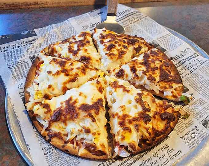 This isn't just pizza &ndash; it's a crispy-edged, cheese-bubbling masterpiece served on newspaper, because some traditions just make food taste better.
