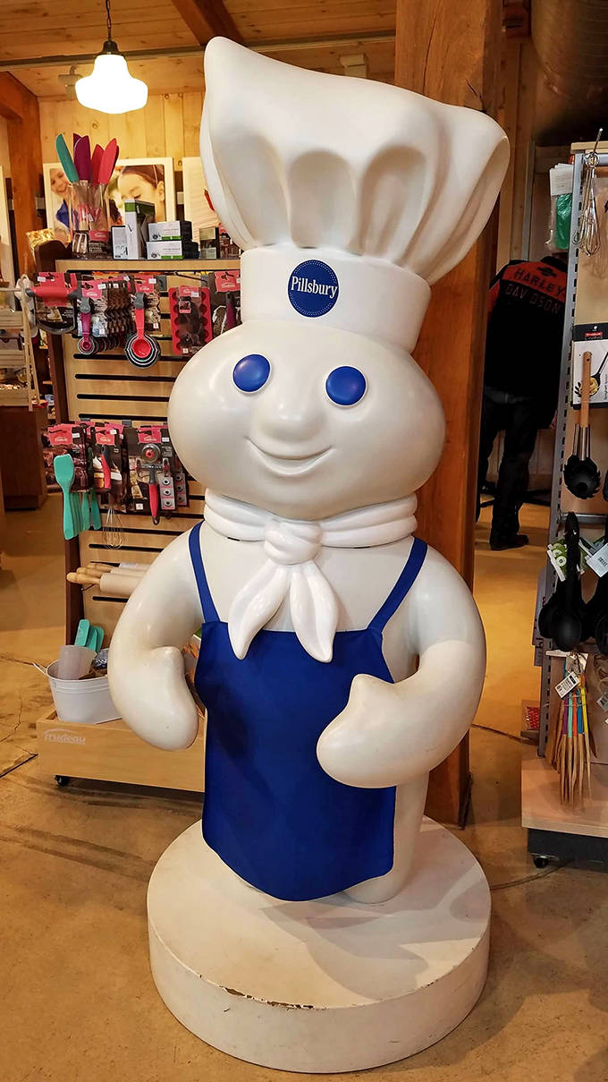 The Pillsbury Doughboy stands at attention, a plump sentinel guarding the baking section with his trademark innocent smile and chef's hat.