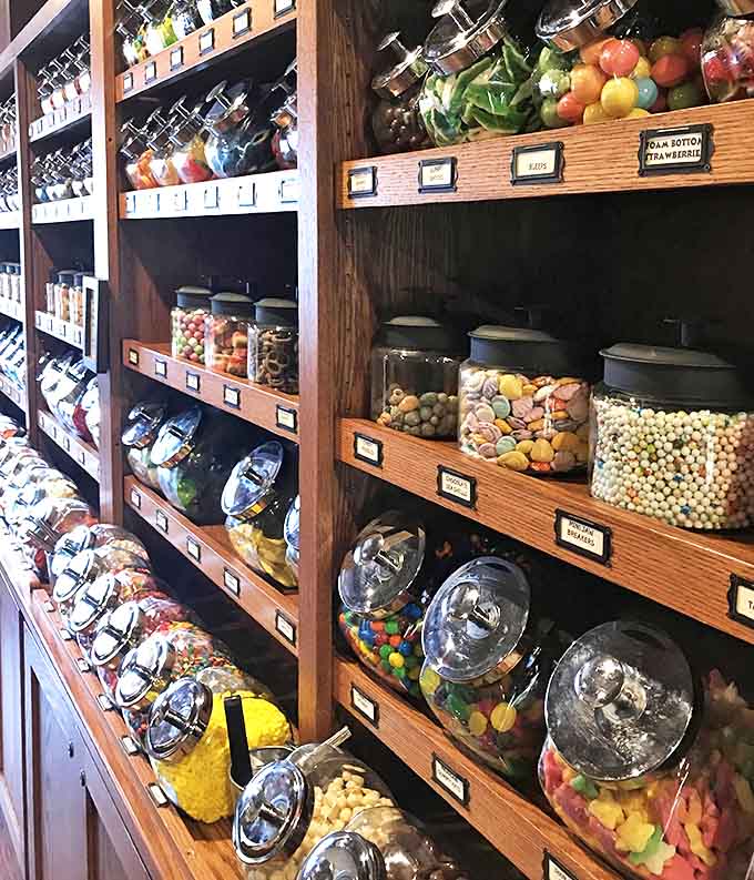 A rainbow of confections awaits in glass containers, each one a portal to childhood memories and future sugar rushes.