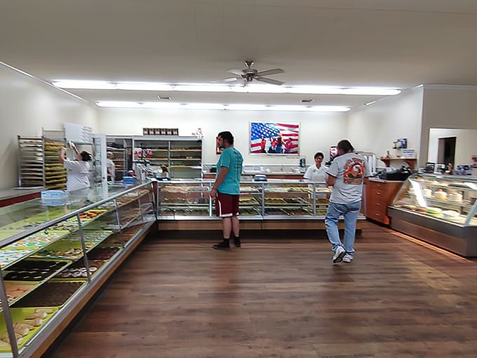 Counter: Donut paradise awaits behind gleaming glass cases. The hardest decision you'll make today? Choosing which heavenly creation to devour first.