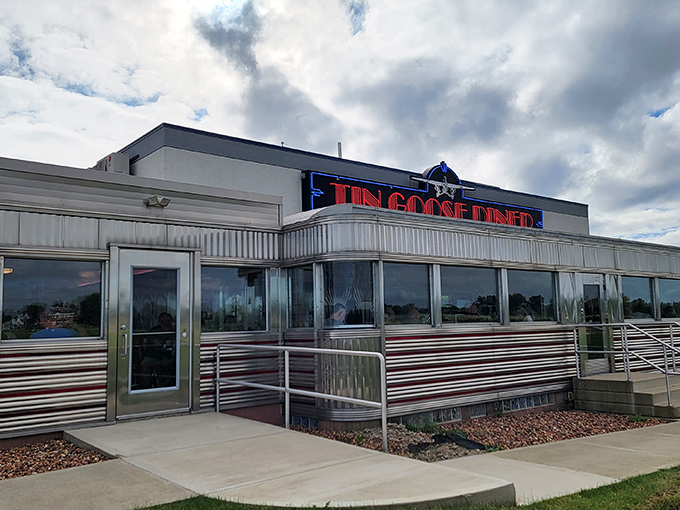 Tin Goose Diner's gleaming stainless steel exterior shines like a beacon for hungry travelers seeking authentic 1950s atmosphere.