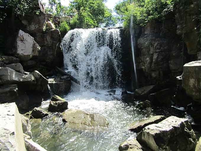 The gentle cascade at Pipestone creates a serene pool that reflects the sky like nature's own mirror in the prairie.
