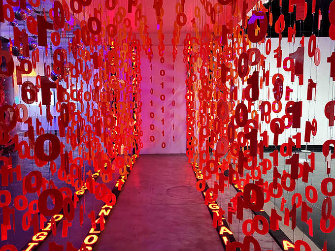 The "Analog to Digital" hallway transforms binary code into a physical experience, with glowing red 1s and 0s creating a Matrix-like passage.