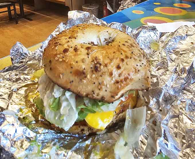 A perfectly toasted everything bagel cradles its fillings like edible architecture, proving simple ingredients can create extraordinary results.