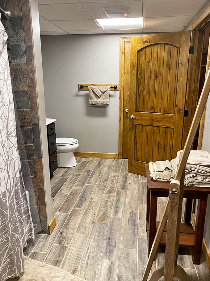Bathroom bliss that proves "rustic" doesn't mean sacrificing comfort &ndash; those wooden doors add charm while hiding modern amenities.