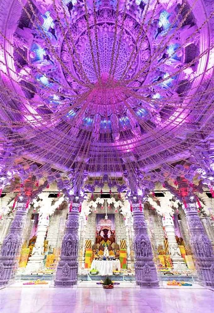 The temple's interior transforms under purple lighting, creating a dreamlike atmosphere where the ceiling seems to float like a crystalline canopy.