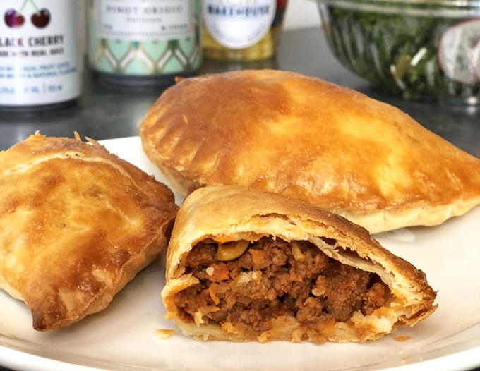 Beef picadillo empanadas with perfectly crimped edges reveal a savory filling that's worth the trip alone. The golden-brown exterior practically whispers, "Take a bite!"