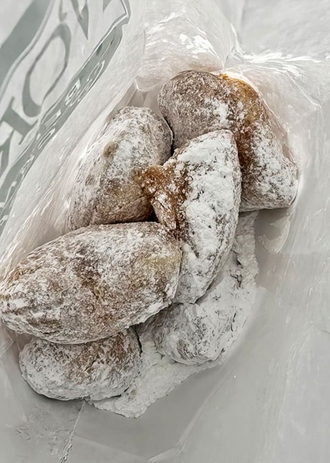 Fresh beignets dusted with enough powdered sugar to create your own personal snowstorm, because subtlety is overrated when it comes to fried dough.