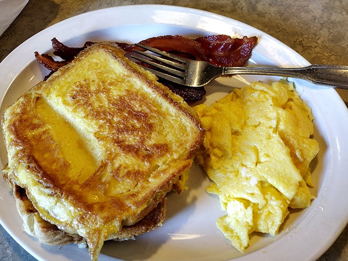 Breakfast sandwich perfection &ndash; golden toast hugging melted cheese and fluffy eggs with crispy bacon standing guard. Morning bliss on a plate.