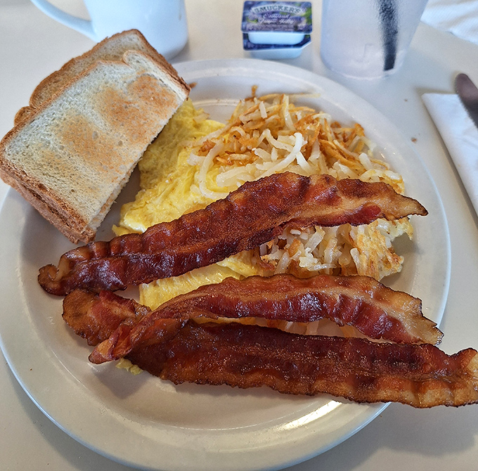 Perfectly scrambled eggs, crispy bacon, and golden hash browns &ndash; the holy trinity of breakfast done absolutely right.