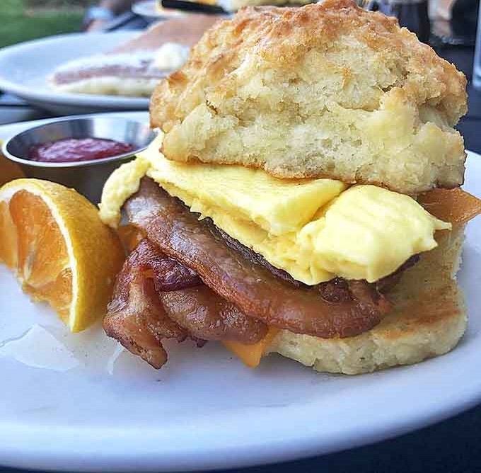 Not all heroes wear capes, some come on biscuits. This breakfast sandwich stacks golden eggs and bacon between cloud-like biscuit layers.