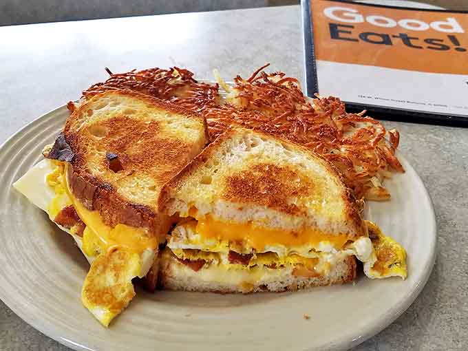 Breakfast sandwich nirvana - golden cheese oozing between toasty bread with crispy hash browns playing the perfect supporting role.