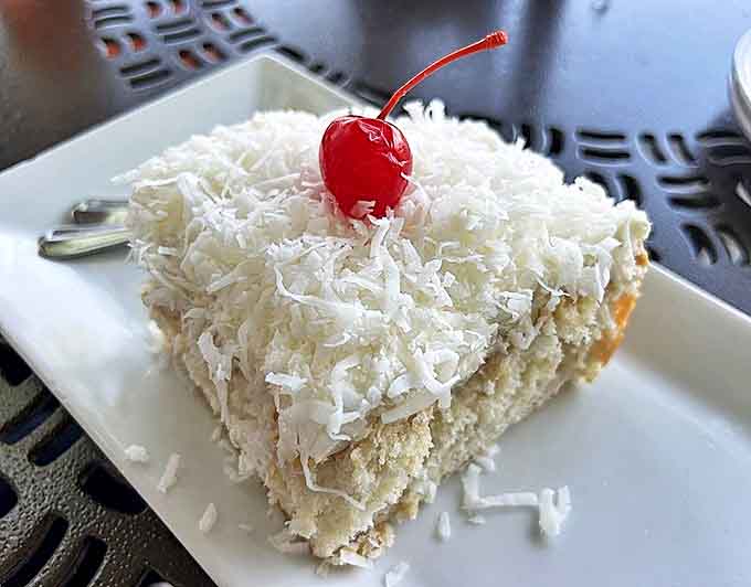 Bunnie's Coconut Cake stands tall and proud, its fluffy white layers crowned with fresh coconut flakes and a cherry, the restaurant's most famous creation.