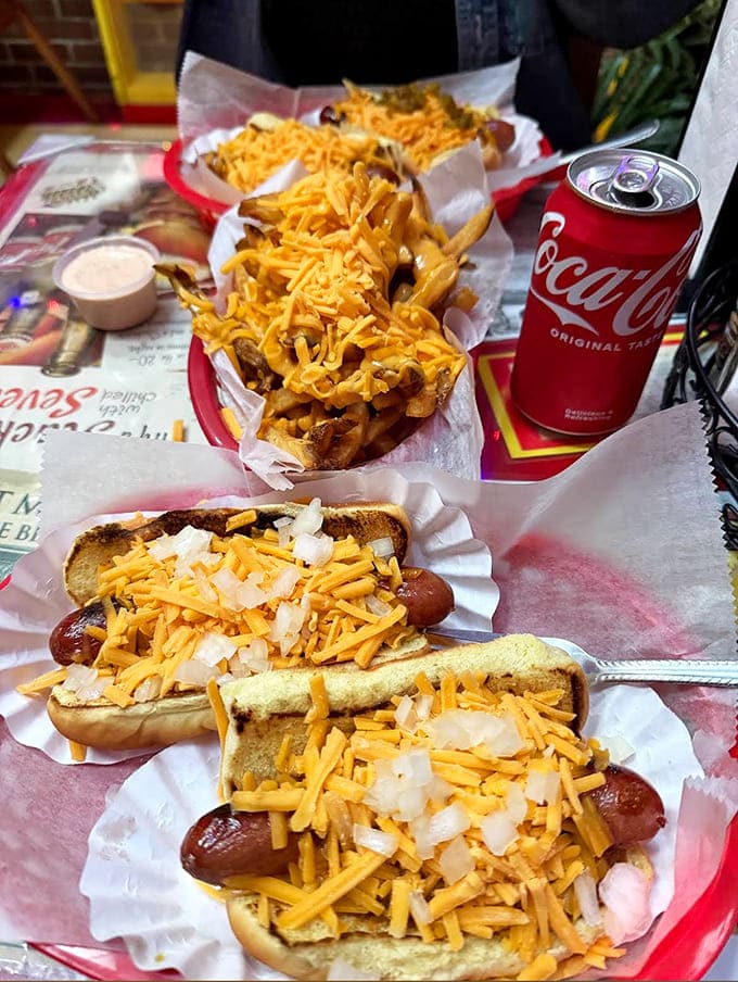 These aren't just hot dogs &ndash; they're edible works of art. Cheese cascades over beef dogs like yellow lava, while onions add texture and punch.