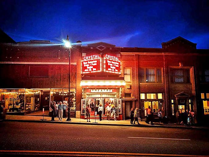 The Crystal Theater's glowing marquee lights up the night, promising entertainment that comes with a side of small-town magic.