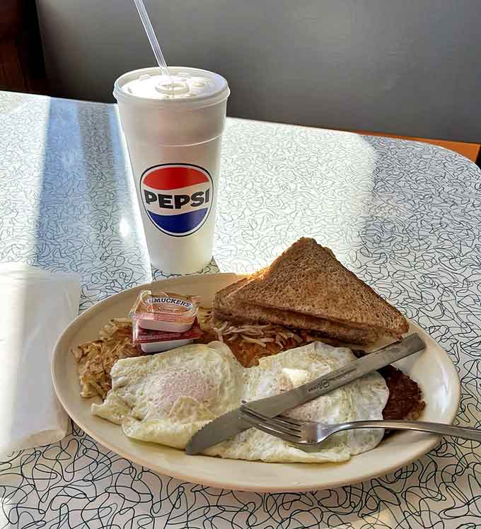 Breakfast doesn't get more authentic than this: perfectly cooked eggs, crispy hash browns, and buttered toast – simple perfection on a plate.