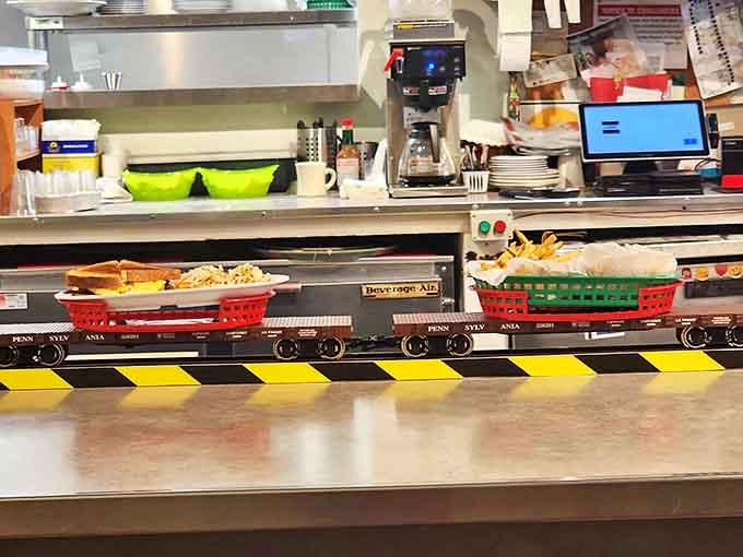 Your burger arrives via locomotive because apparently someone finally figured out the perfect delivery system and it's absolutely genius.