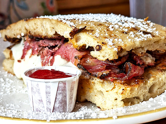 Behold the crown jewel: a pastrami sandwich that would make Manhattan delis weep with envy. That powdered sugar dusting? Culinary genius.