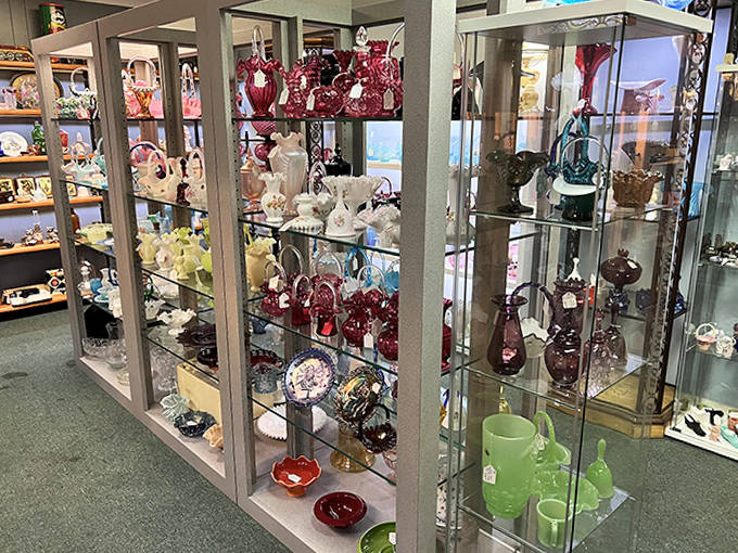 These glass display cases protect the delicate treasures like a museum, showcasing everything from ruby red vases to Depression glass that catches light like liquid jewels.