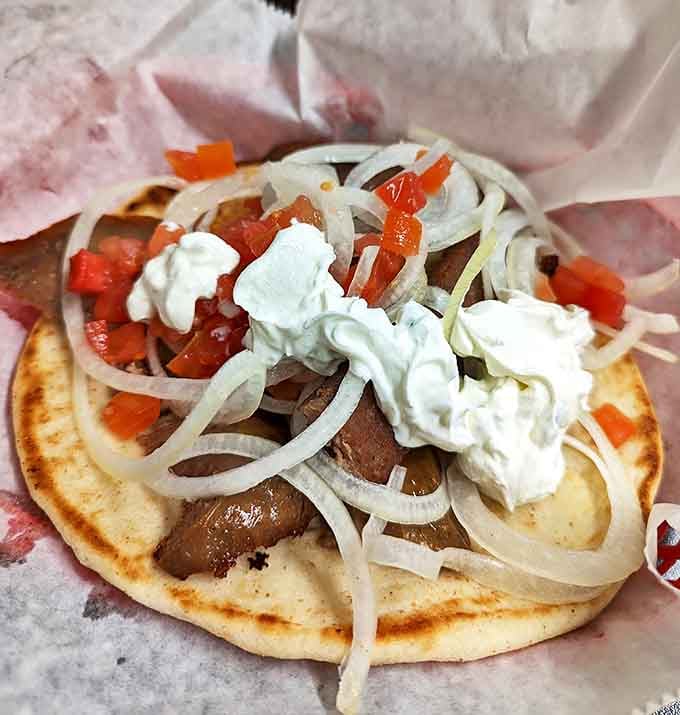 This isn't just any gyro &ndash; it's a perfect handheld symphony of savory meat, fresh veggies, and creamy tzatziki that demands to be devoured.