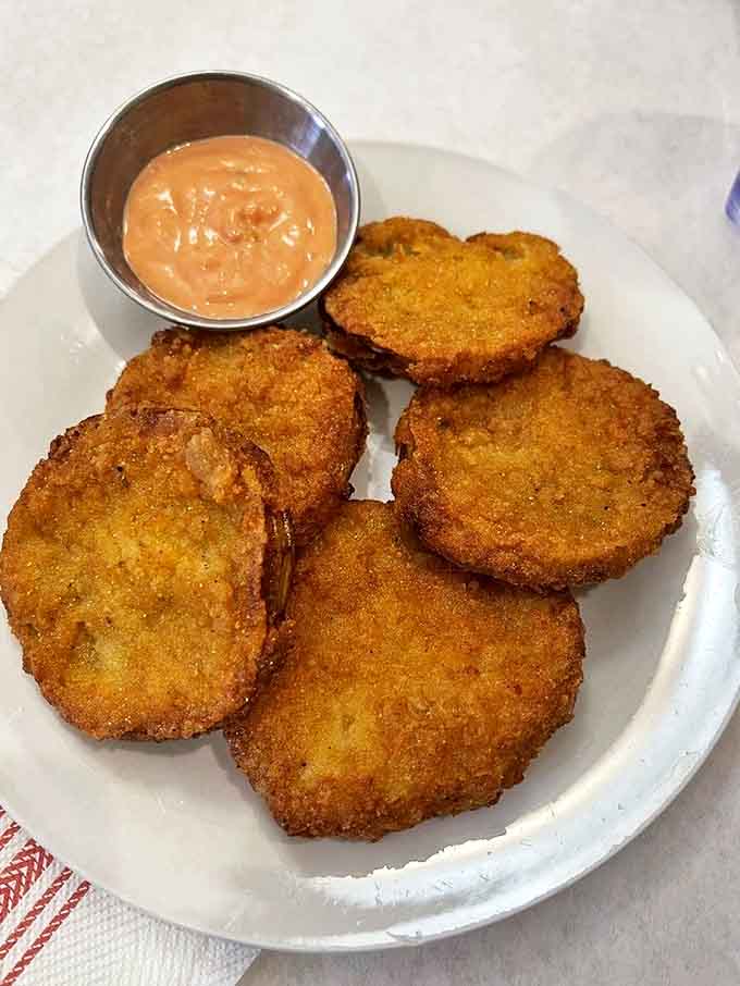 These fried green tomatoes aren't just appetizers &ndash; they're crispy, golden discs of Southern tradition served with a sauce that kicks like a mule.