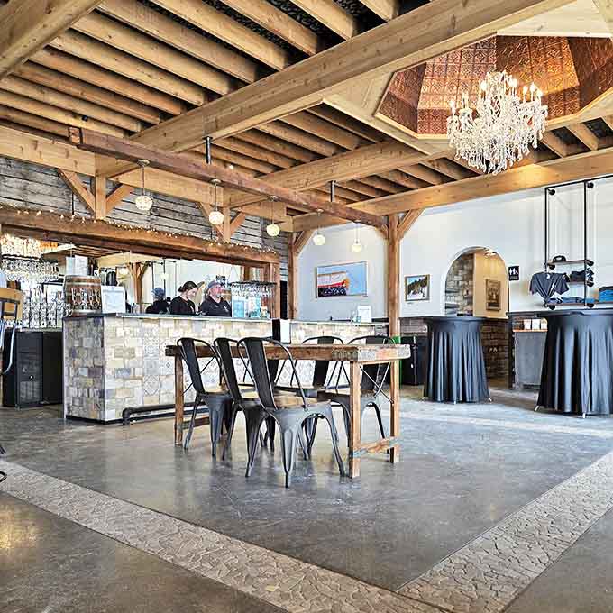 Rustic meets refined with exposed beams, crystal chandeliers, and stone accents creating a tasting room that feels both elegant and approachable.