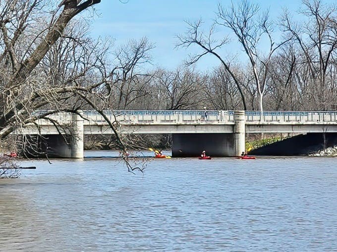 Kayakers on water: Beneath the concrete arteries of modern life, paddlers discover the lagoon's peaceful pulse, a liquid highway far from traffic jams.