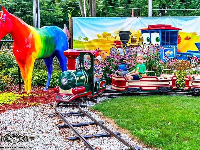 All aboard the nostalgia express! The kiddie train chugs past a rainbow-colored horse, creating picture-perfect childhood memories.