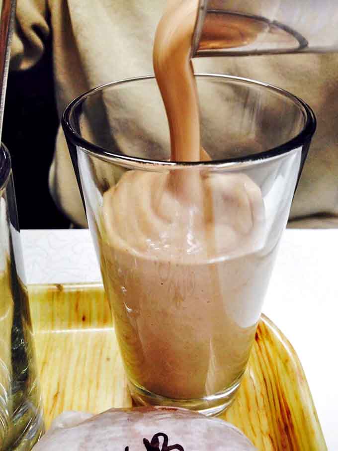 Chocolate milkshake perfection cascading into a waiting glass &ndash; this isn't just a drink, it's a commitment to happiness.