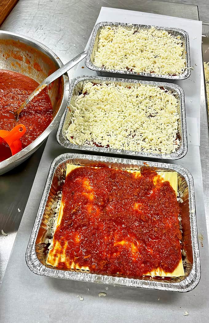 Behold the lasagna assembly line, where layers of pasta, meat sauce, and cheese come together like the Italian version of a construction project.