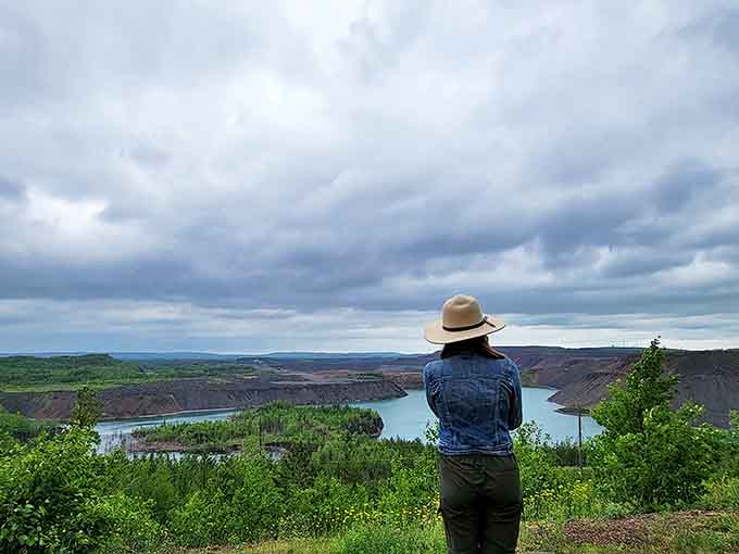 A visitor takes in the panoramic majesty of Minnesota's Iron Range, where history and natural beauty collide in one breathtaking vista.