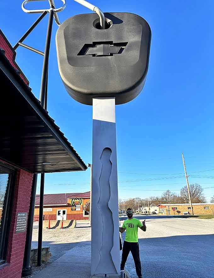 "I've got the keys to the city!" This enthusiastic visitor strikes a pose beside Casey's automotive monument.