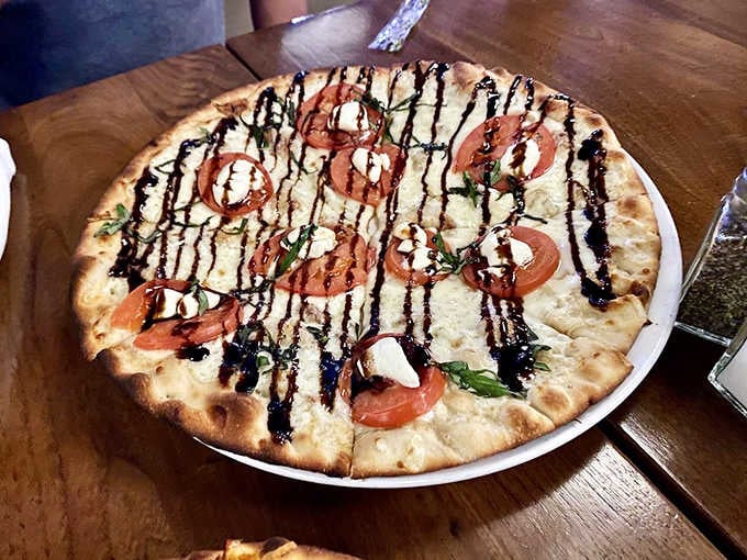 This isn't your average pizza joint's Margherita &ndash; fresh tomatoes, mozzarella, and balsamic drizzle create a perfect harmony of flavors.