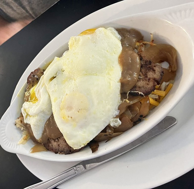 This isn't just meatloaf &ndash; it's a masterpiece of comfort food architecture, topped with eggs and smothered in gravy that grandma would approve of.