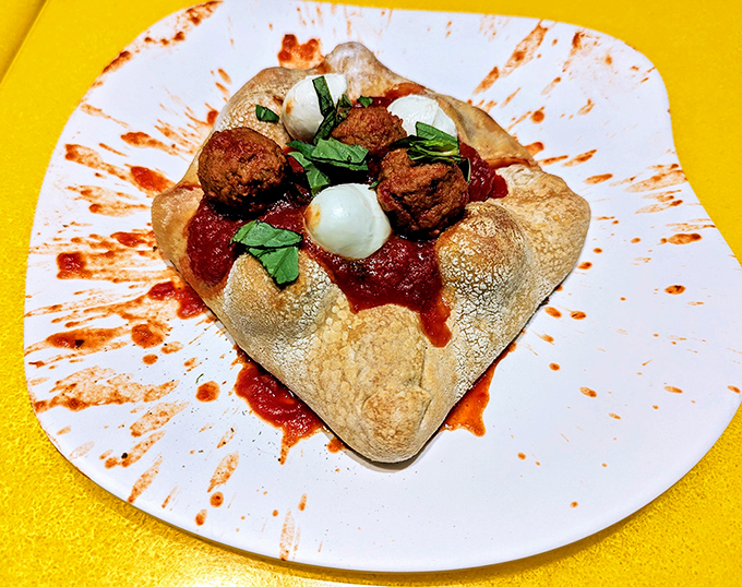 Mel's Meatball Mountain isn't just food &ndash; it's edible architecture, with meatballs perched dramatically on bread, surrounded by a splash of marinara artistry.