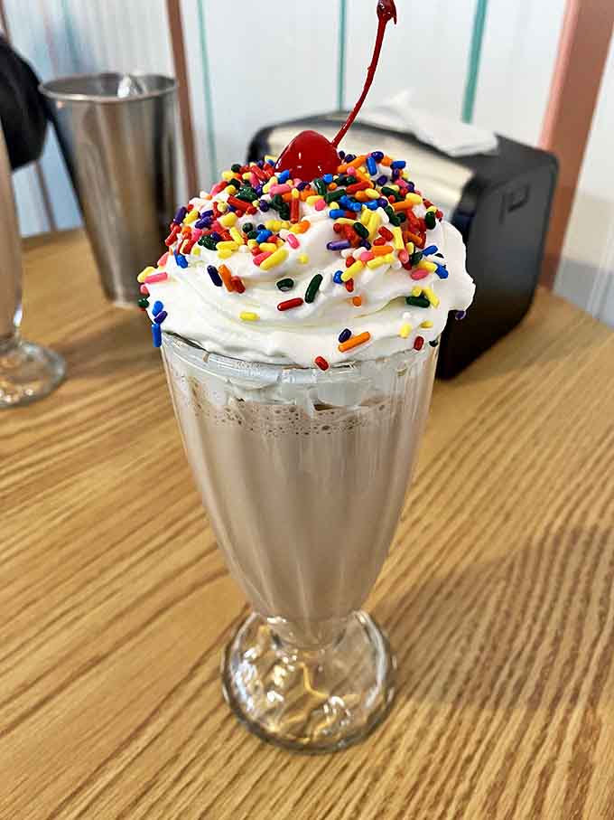 This isn't just a milkshake &ndash; it's architecture in a glass! Whipped cream mountain, rainbow sprinkle rainfall, and that cherry on top that somehow tastes better here.