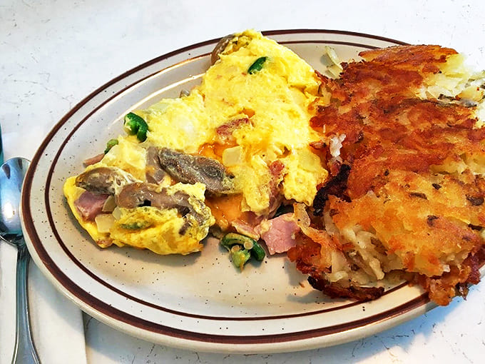 This isn't just any omelet – it's a fluffy envelope of breakfast joy, stuffed with goodies and paired with those famous hash browns.