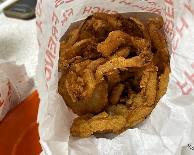 Golden, crispy onion rings that crunch so loudly they might set off car alarms. Worth every decibel.