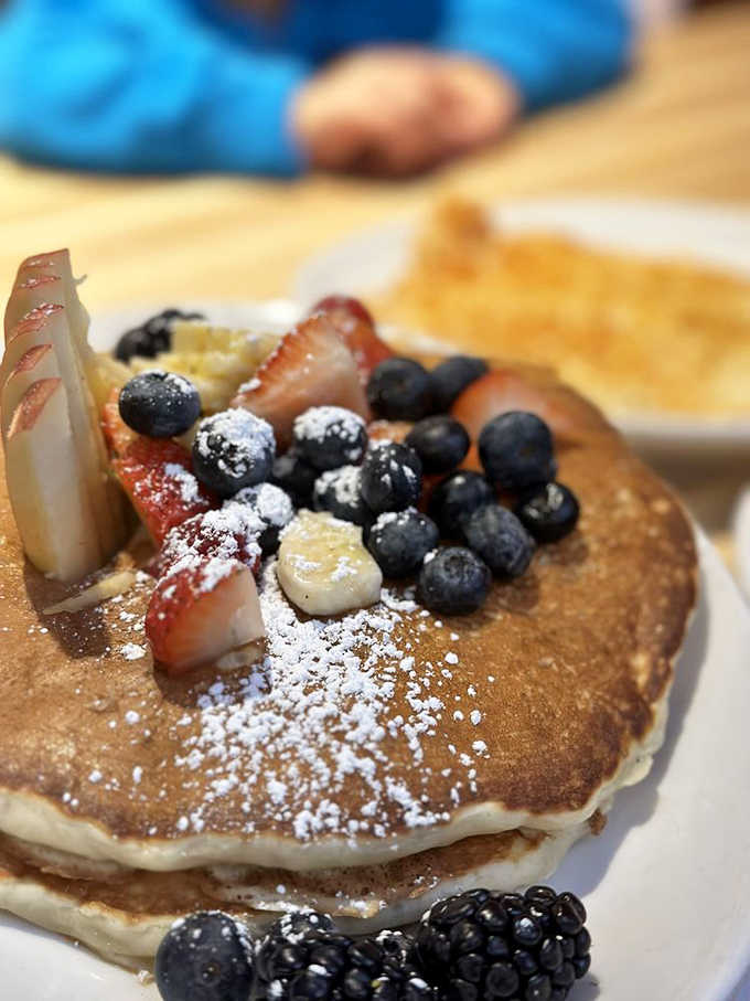 These aren't just pancakes, they're cloud-like creations topped with fresh berries and a dusting of powdered sugar that'll make you question all other breakfasts.