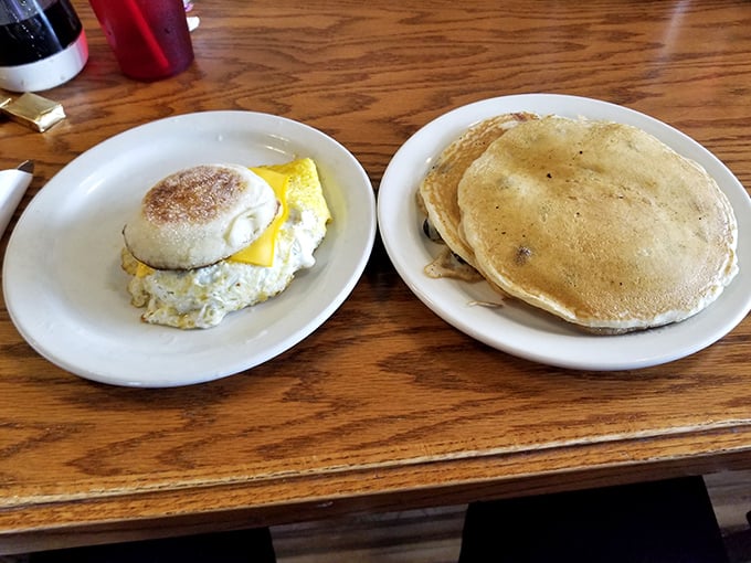 A perfect breakfast duo: golden pancakes stacked alongside a breakfast sandwich that proves simplicity, when done right, is the ultimate luxury.
