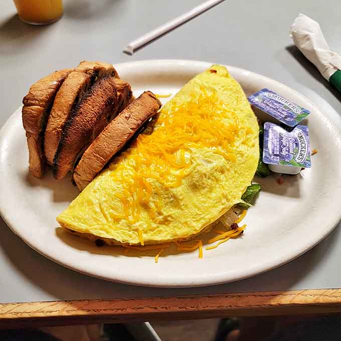This isn't just an omelet &ndash; it's an architectural achievement of egg engineering. Perfectly folded around melty cheese with toast standing guard nearby.